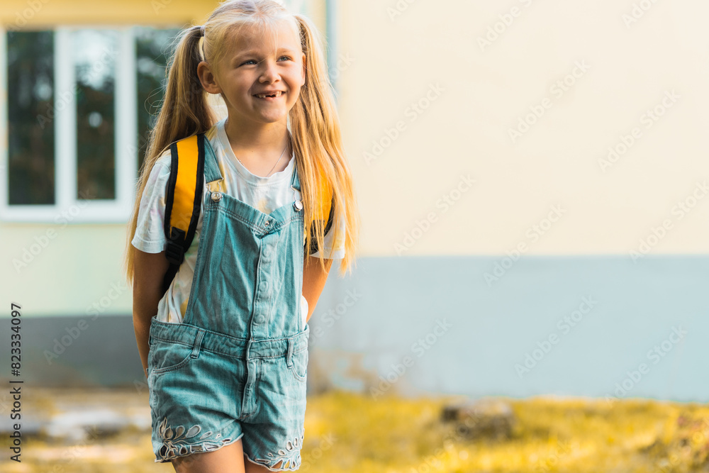Cute smiling little girl with backpack on a greenery background ...