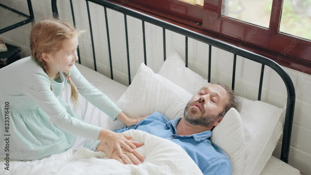 Little cute daughter walk to wake up deep sleeping father on bed at ...