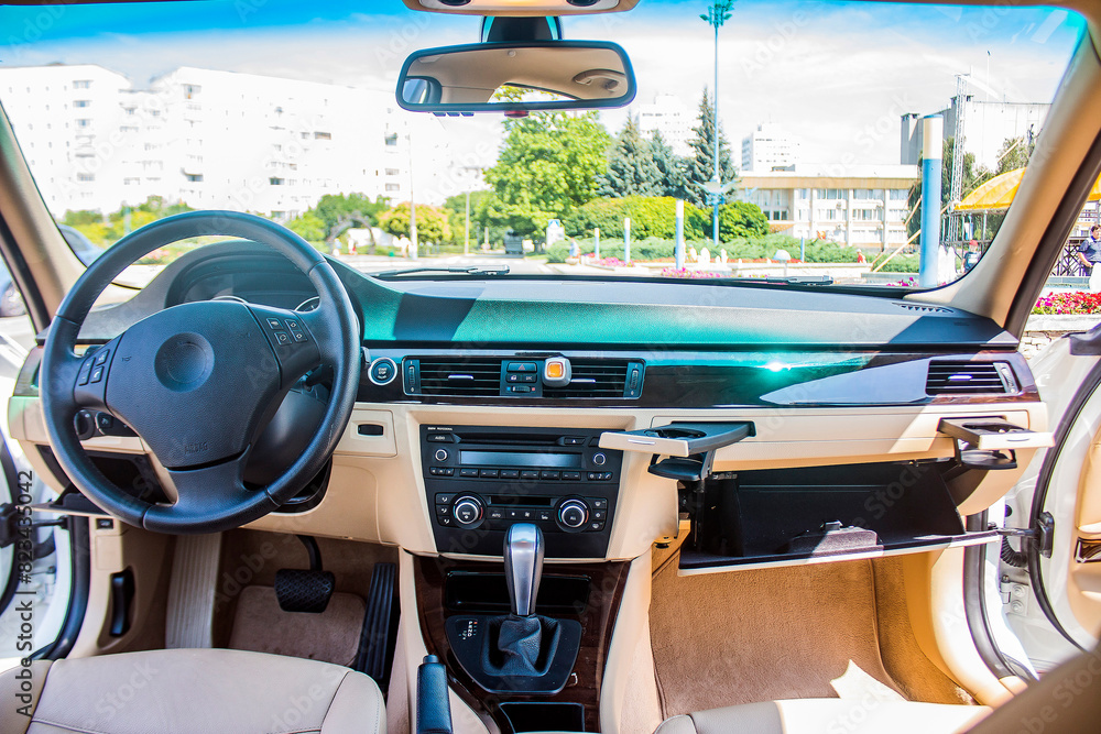 Black and beige dashboard and steering wheel of a car with an open ...