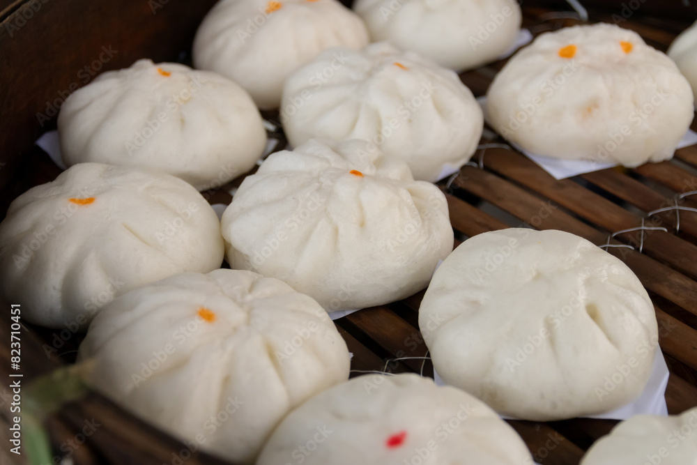Bamboo basket of hot steamed barbecue pork bun, minced pork bun and ...