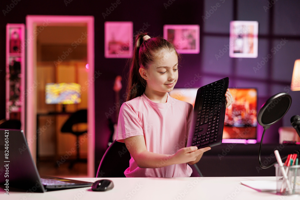 Small girl showing subscribers mechanical keyboard received from ...