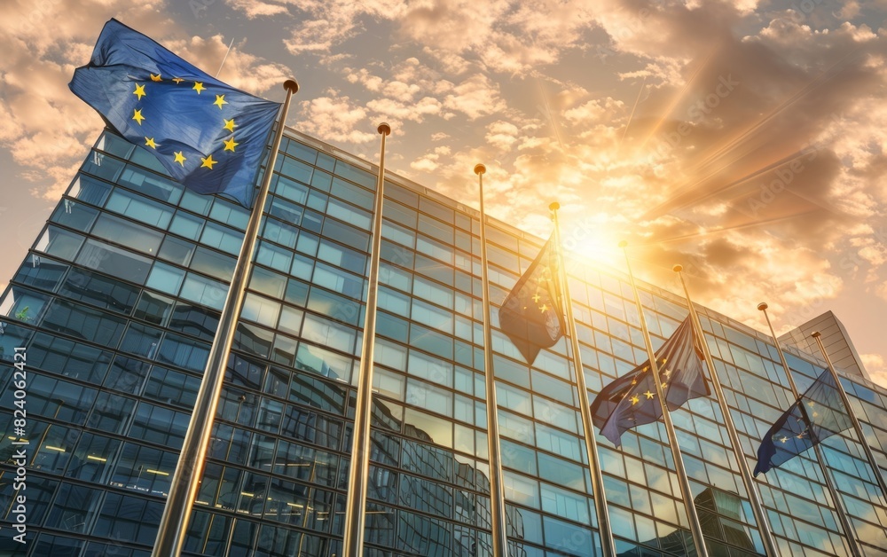 EU flags fluttering in front of a modern glass building under a radiant ...