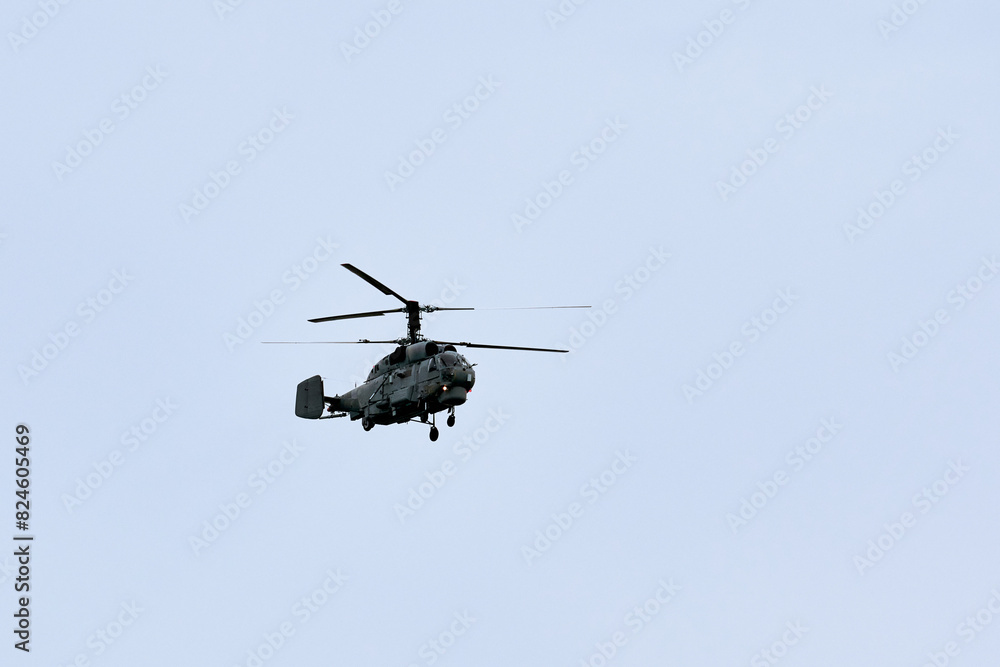 Russian military helicopter armed with missiles flies in blue sky ...