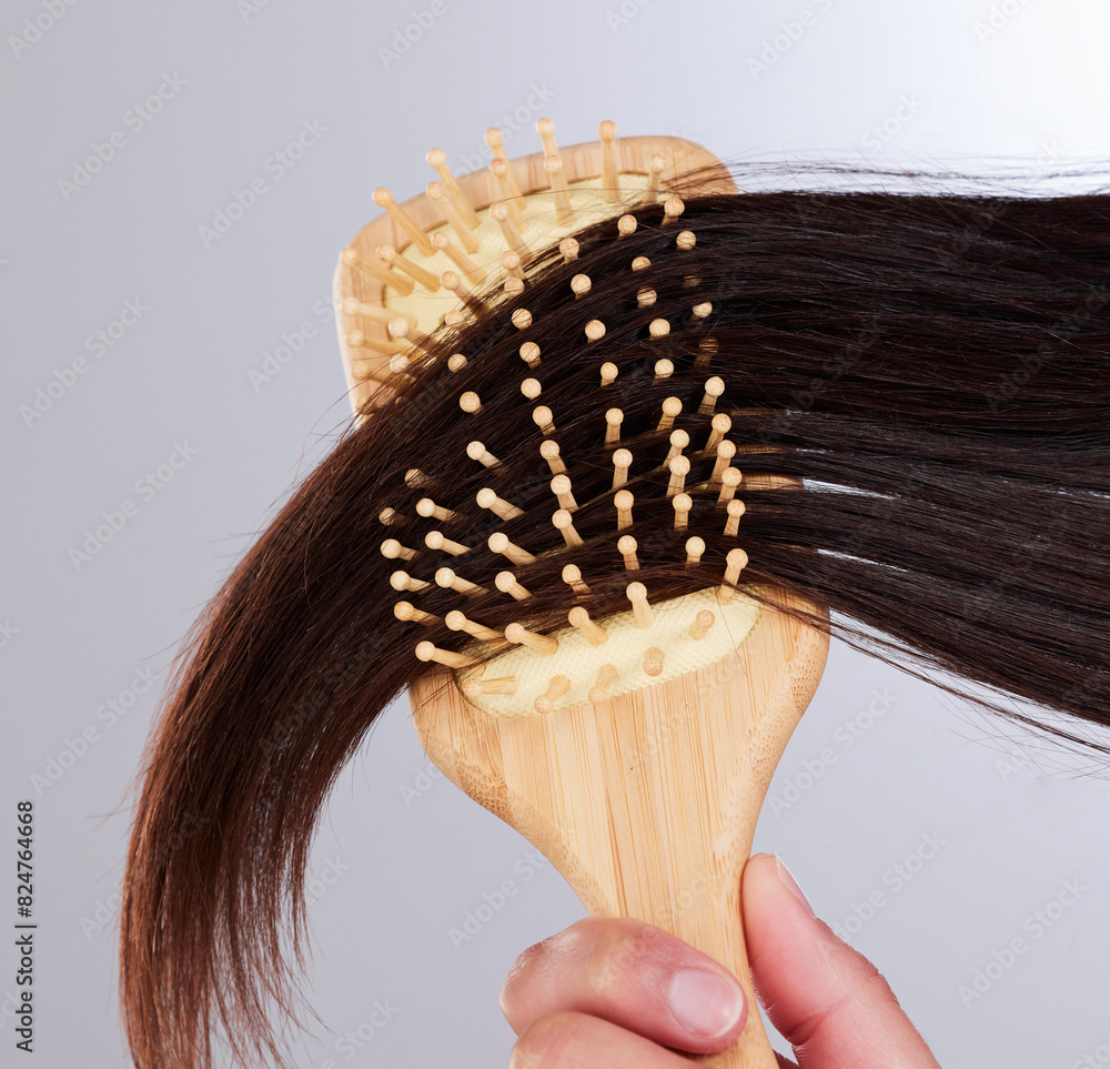 Brush, hair and hand of hairdresser in studio, closeup and haircare in ...
