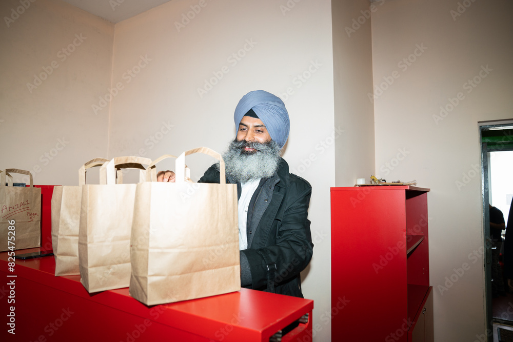 Indian Restaurant Owner Checking Take Away Orders Stock Photo | Adobe Stock