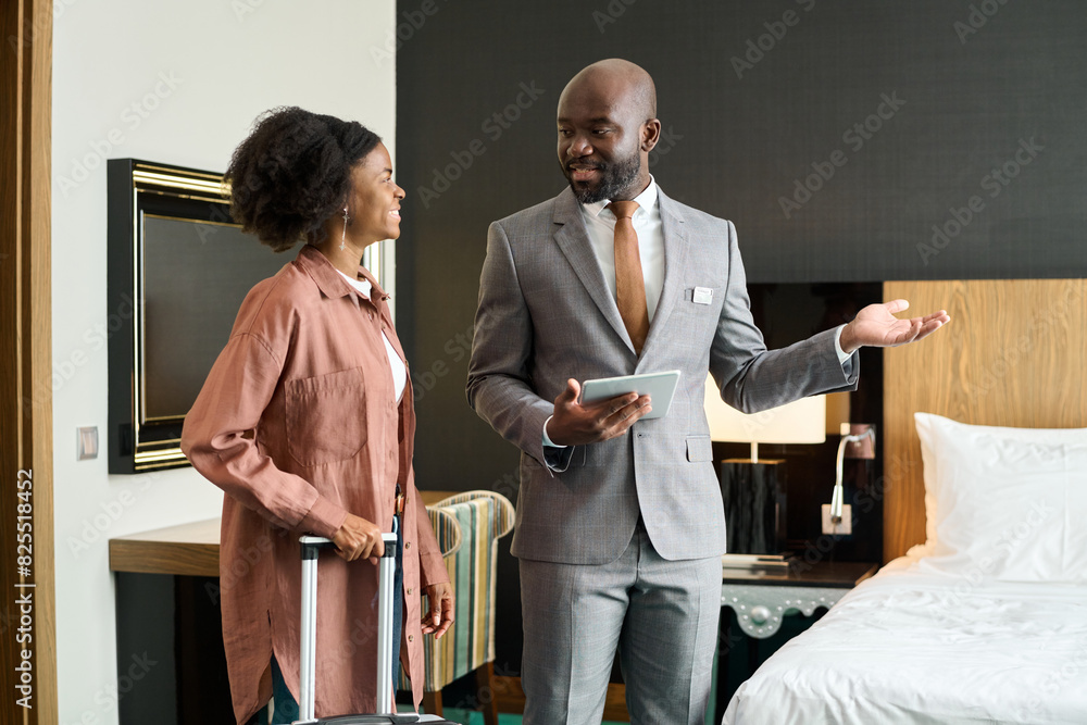 Portrait of luxury hotel manager welcoming young Black woman entering ...