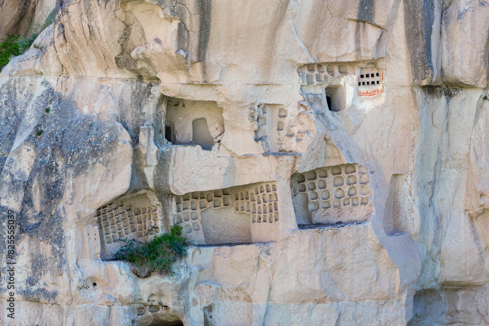 Detailed view of ancient carved caves in Cappadocia with intricate ...