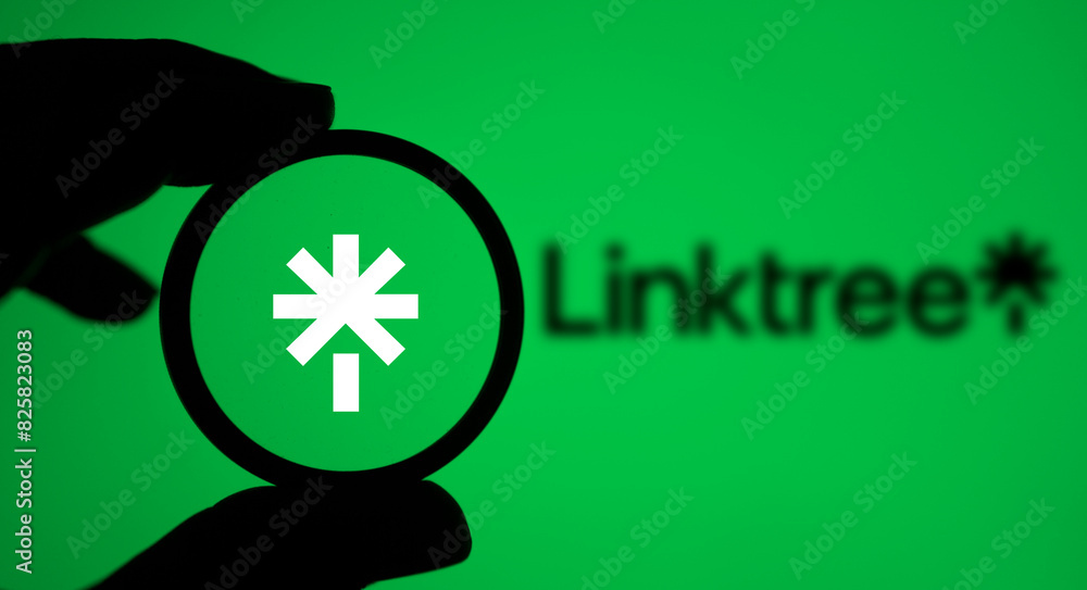 Dhaka, Bangladesh- 24 May 2024: A person holding a magnifying glass to inspect the logo of ...