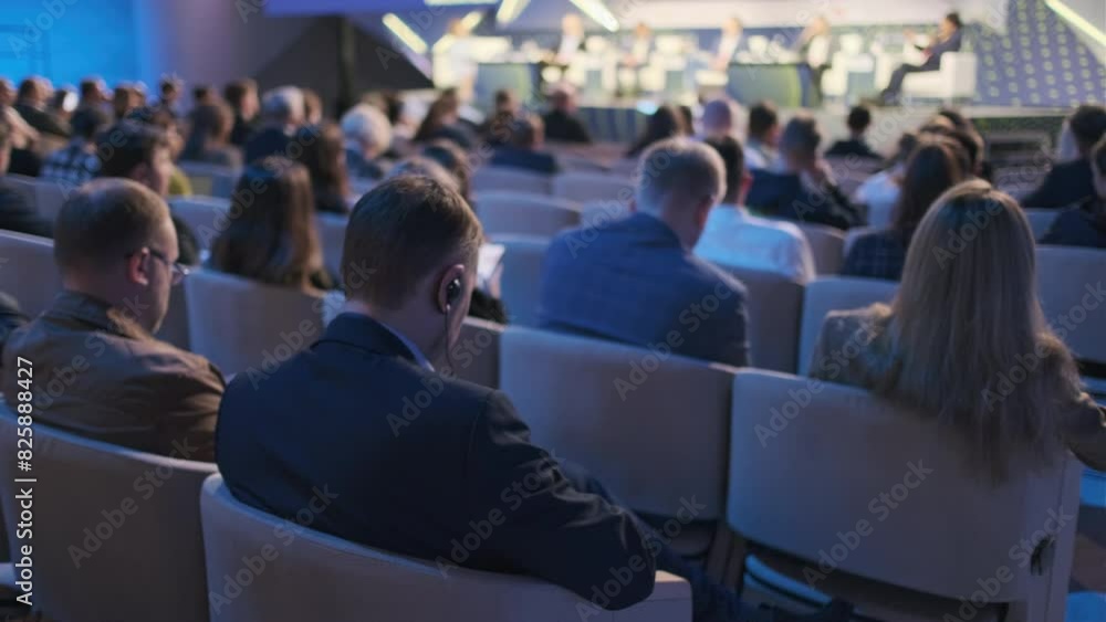 Focused audience at a business conference watching and listening to ...