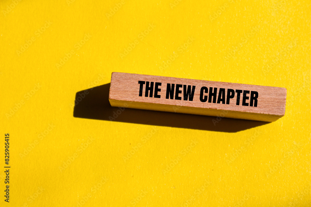 The new chapter words written on wooden block with yellow background ...