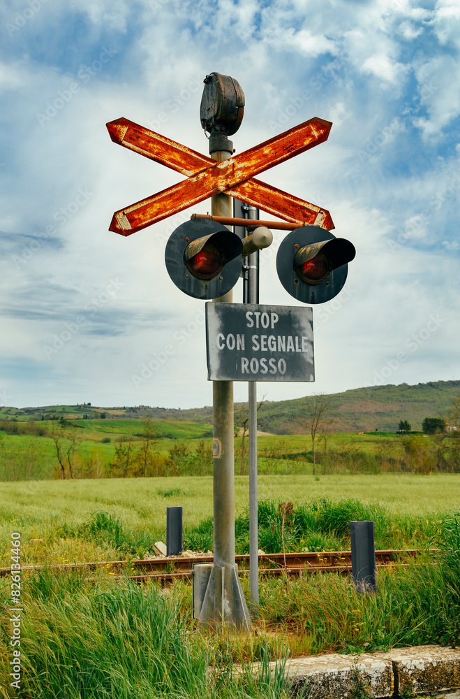One old railway traffic light with a stop sign in Italian stands next ...
