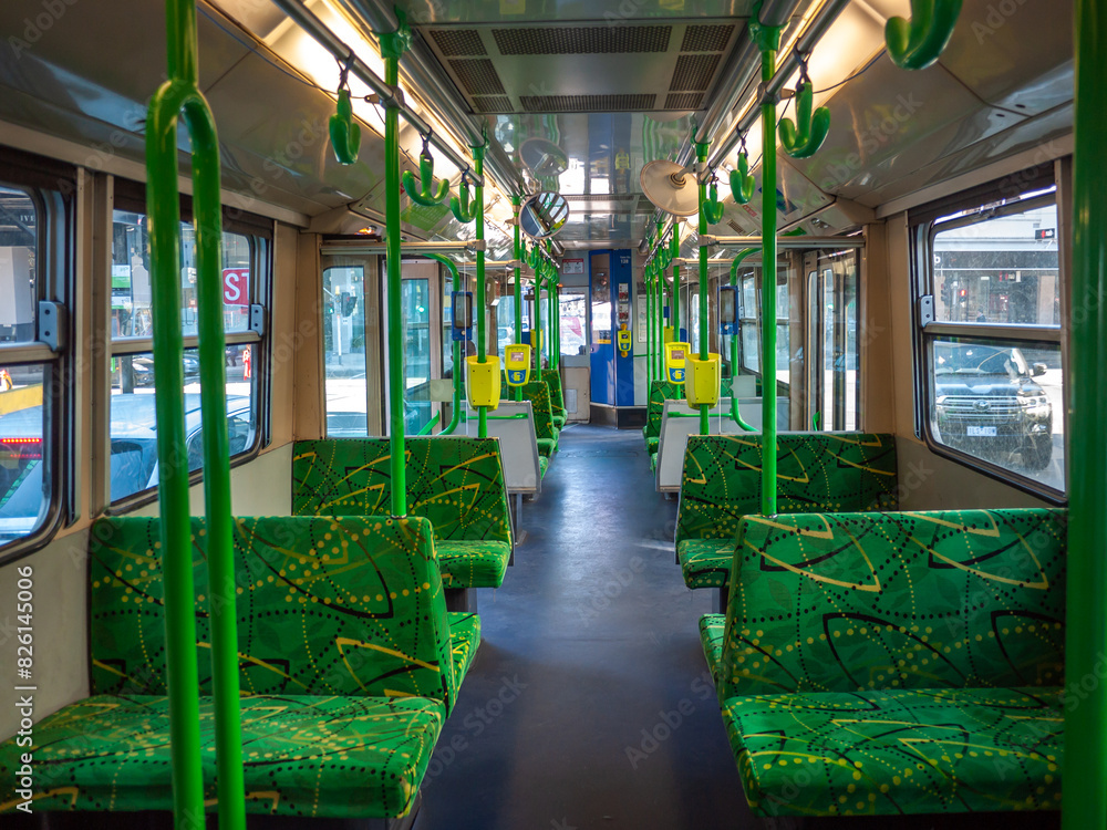 The interior of a tram with seats, handlebars, and ticket scanning ...