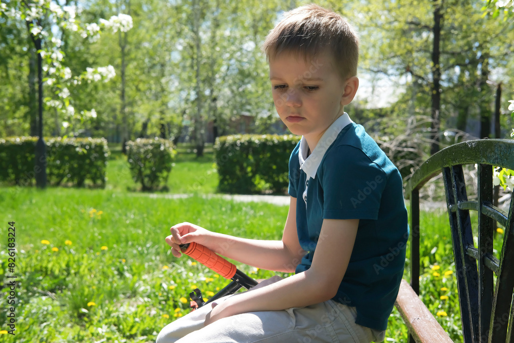 Boy is crying alone in park on bench, sitting and sad because of broken ...