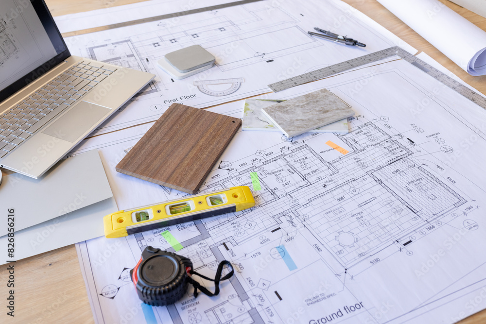 Architectural plans and tools spread out on desk, showing detailed ...