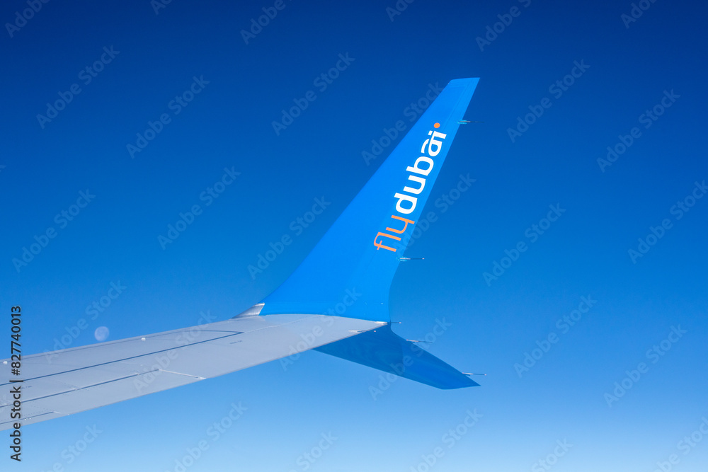 Dubai, UAE - May 14, 2024: Flydubai airplane wing in flight with clear ...
