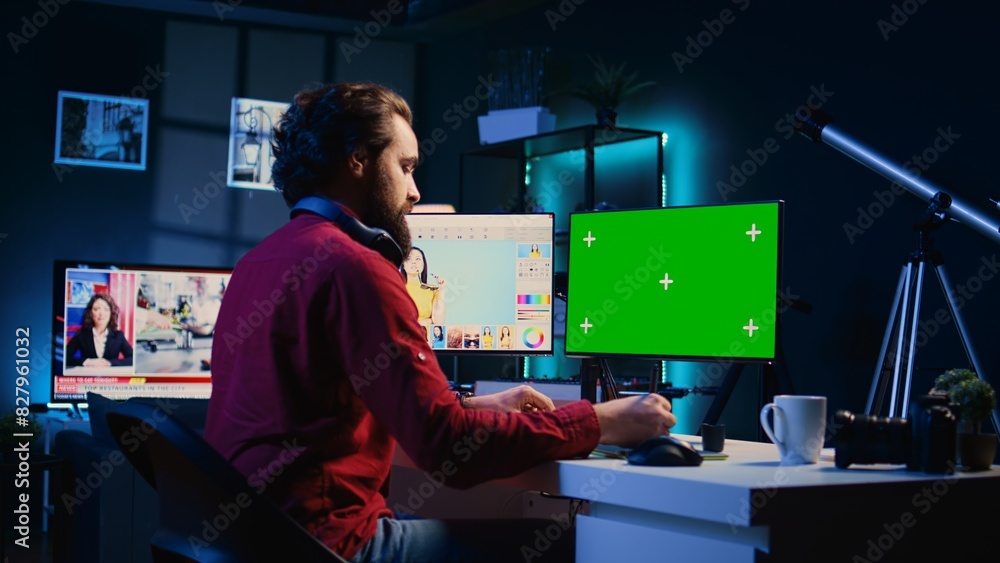 Photographer uses photo editing software on green screen PC display in ...