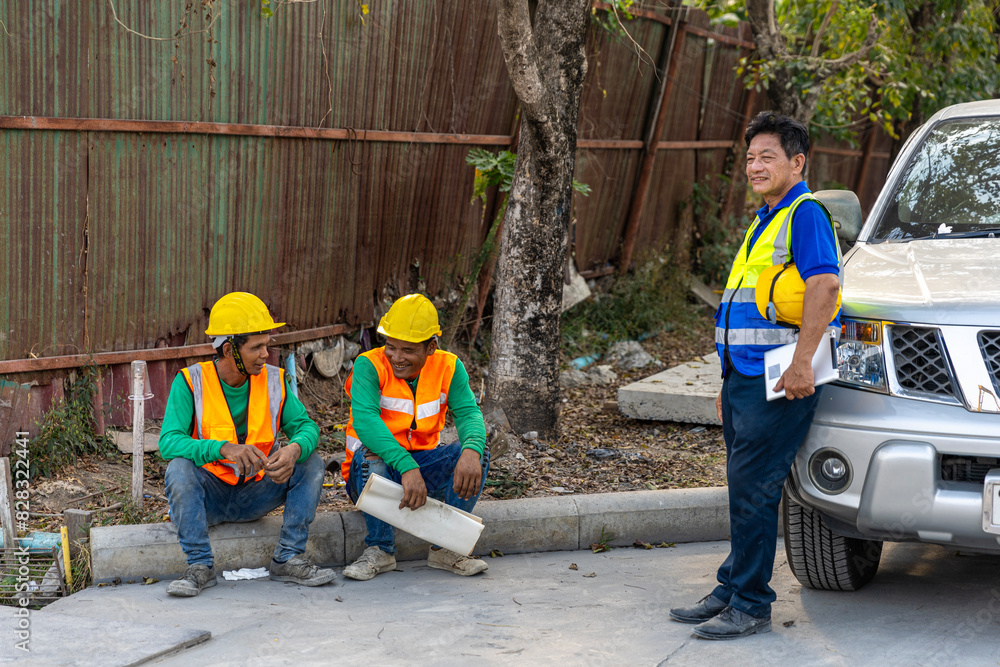 Team of civil engineers or workers in safety suits taking rest after a ...