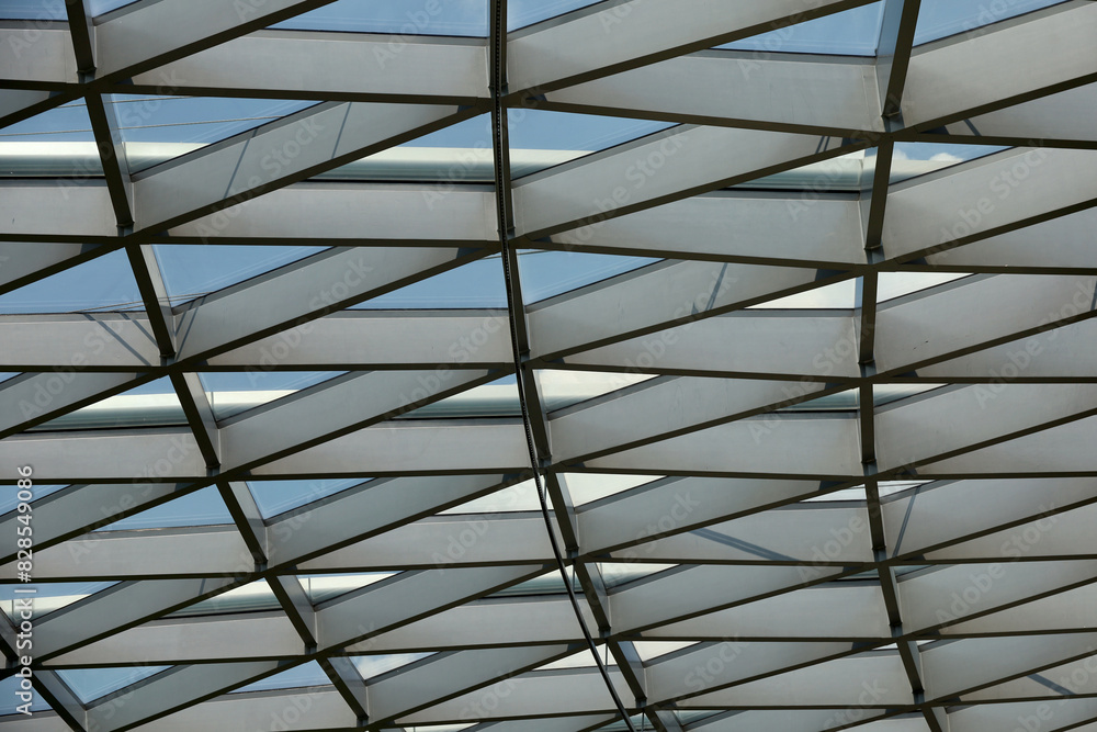 An upward view of a modern geometric glass roof construction, featuring ...