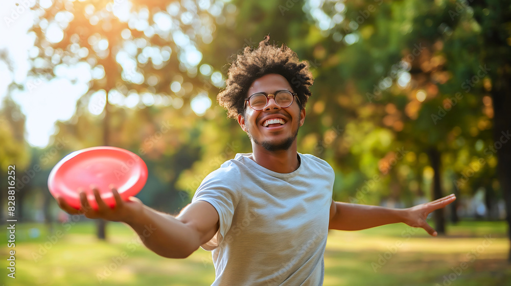 Happy young African American man playing with frisbee in nature park ...