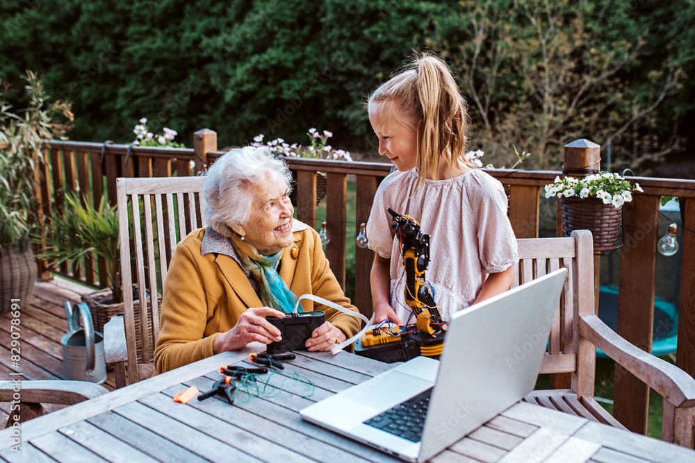 Grandmother supporting granddaughter in robotics, science, IT ...
