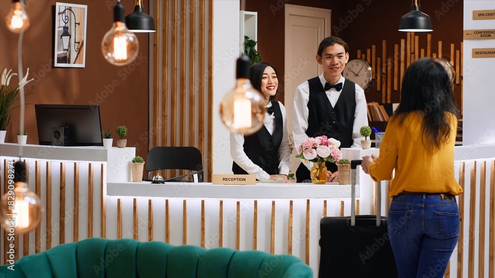 Front desk team greeting guest at five star hotel reception, welcoming ...
