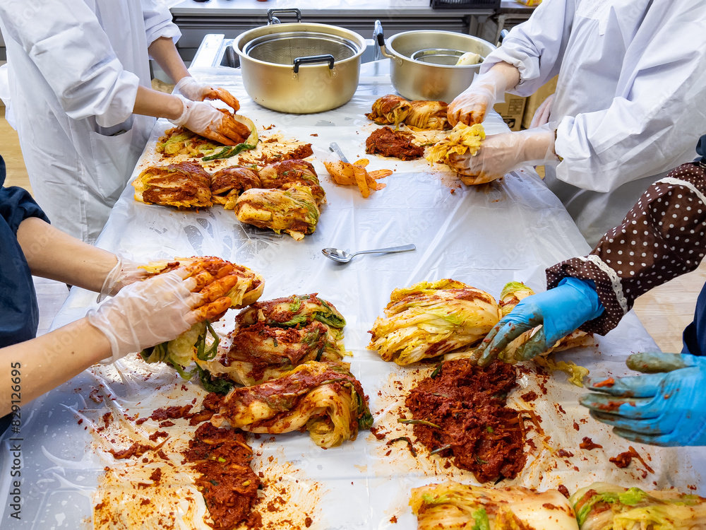 Women are making the traditional Korean kimchi with cabbage (Napa ...