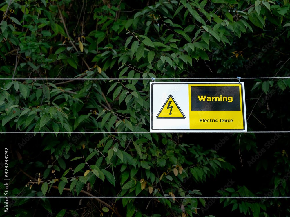 Electrical fence warning sign with electric shock icon installed on ...