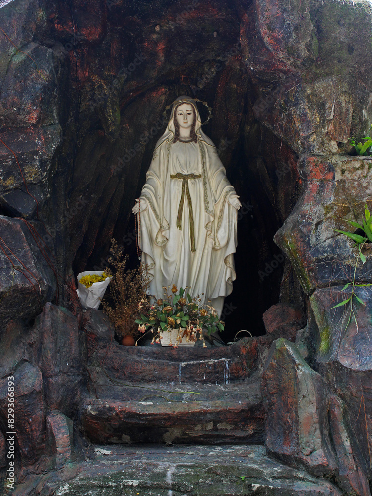 View of the statue of the Virgin Mary in an artificial grotto. Stock ...