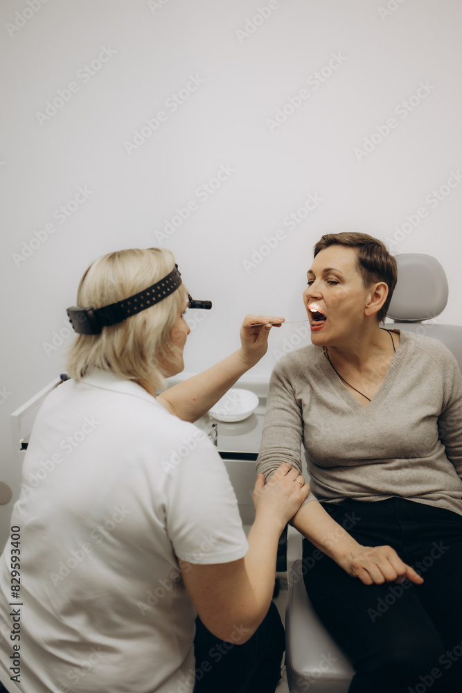 ENT doctor examines the nasal cavity of the patient in the office of ...