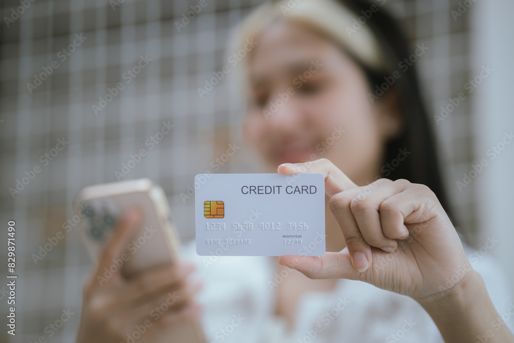 Attractive millennia Asian female holding her smartphone and credit ...