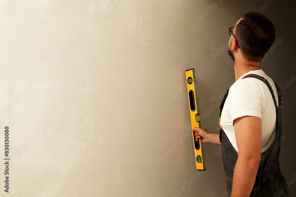 Professional using level tool on wall, clean background, excellent for ...