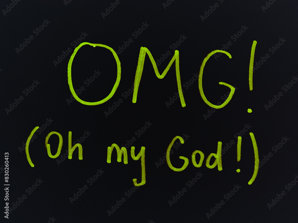 Word "omg", written on a sheet o fblack paper, various words and ...