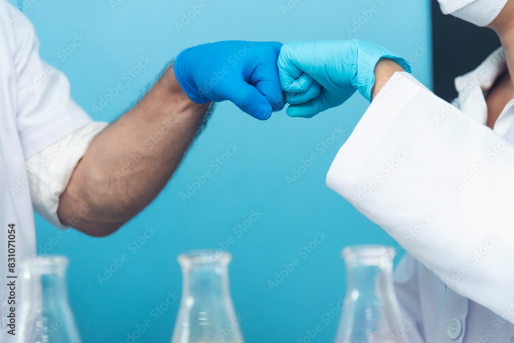 Foto de Two caucasian scientist men woman fist bump team partner shake ...
