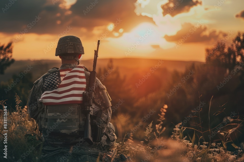 Soldier in uniform sitting at sunset with American flag draped over ...