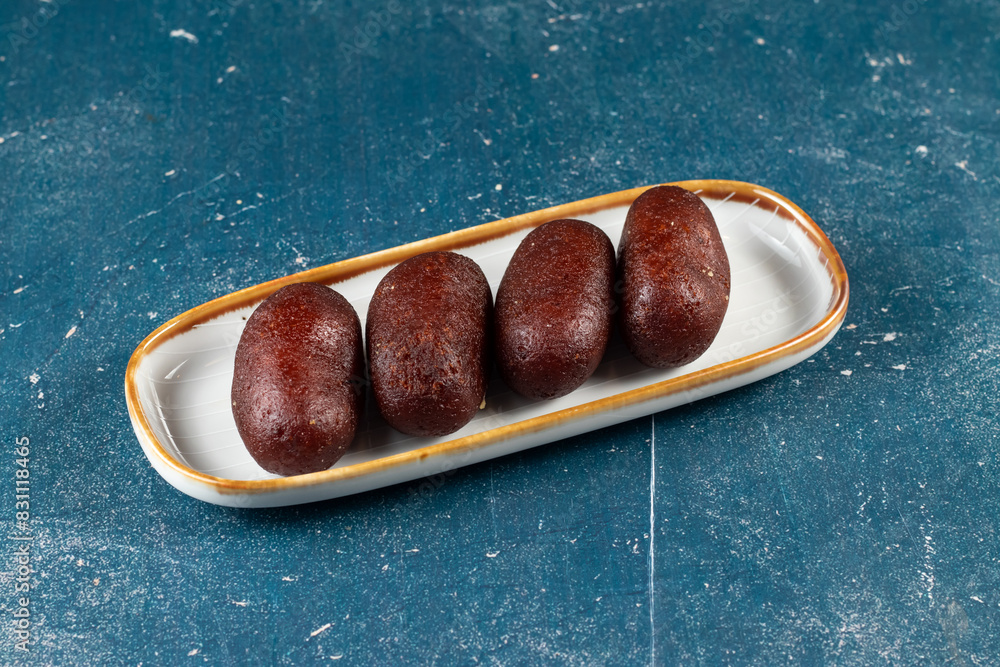Gulab Jamun, kalo jam or mohan served in tray dish isolated on navy ...