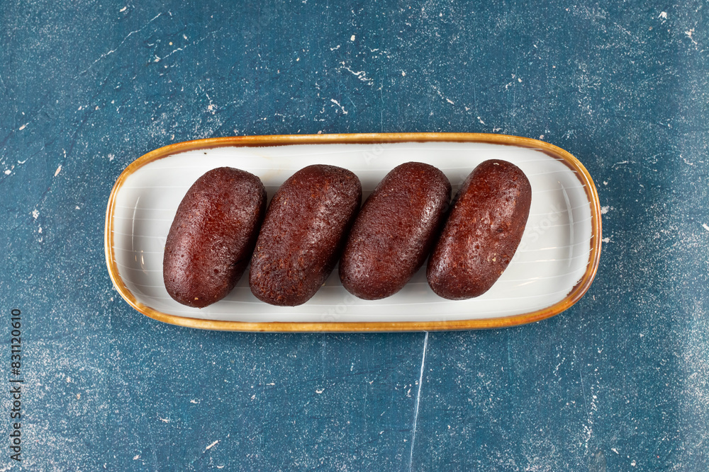 Gulab Jamun, kalo jam or mohan served in tray dish isolated on navy ...