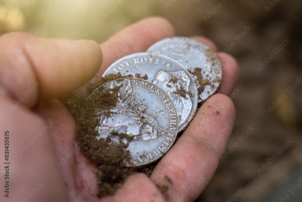 The treasure hunter.Excavation of old coins in the ground. An ancient ...