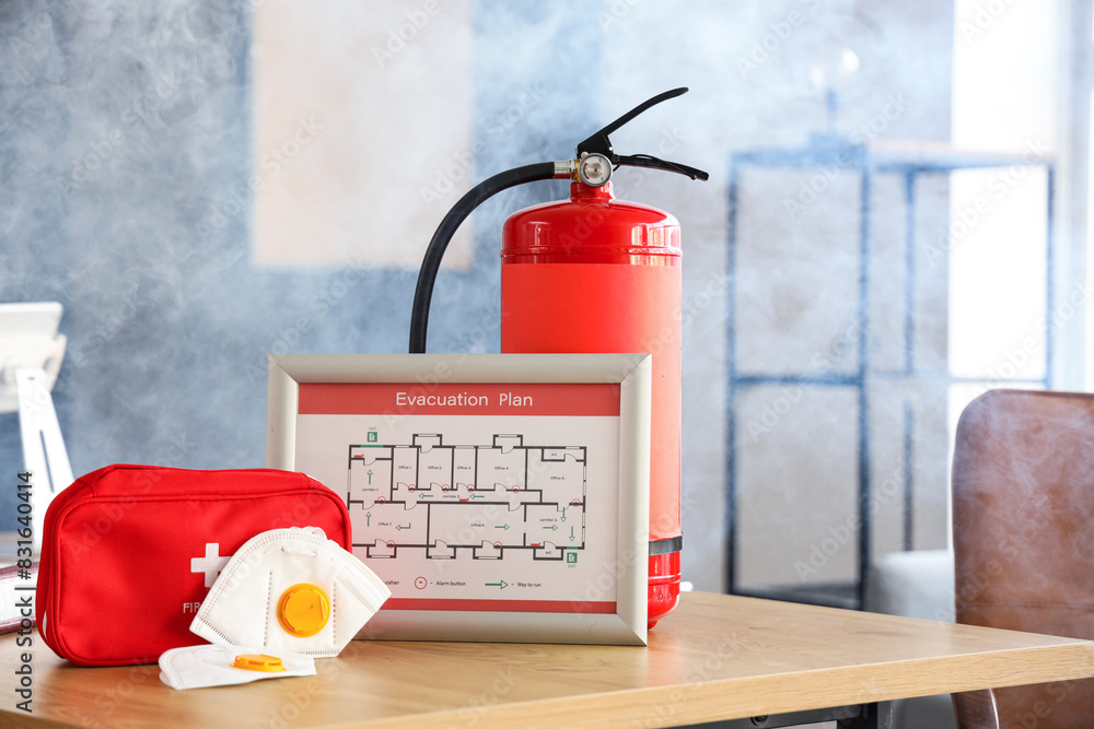 Evacuation plan with masks, first aid kit and fire extinguisher on ...