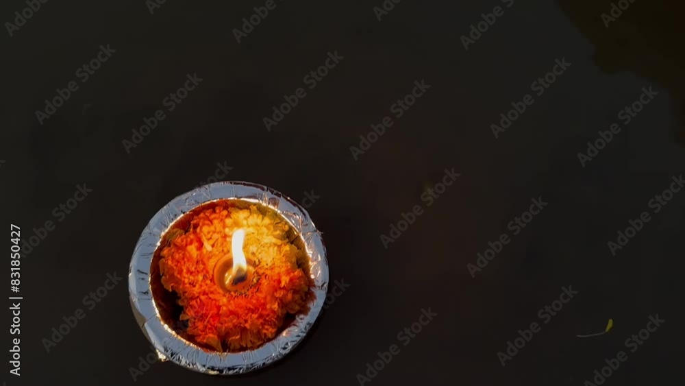 Ganga aarti, Fire flame along with rose and marigold flower floating in ...
