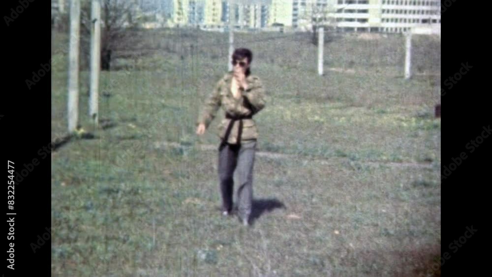 Caucasian Man in Karate kimono running by green grass, on sunny summer ...