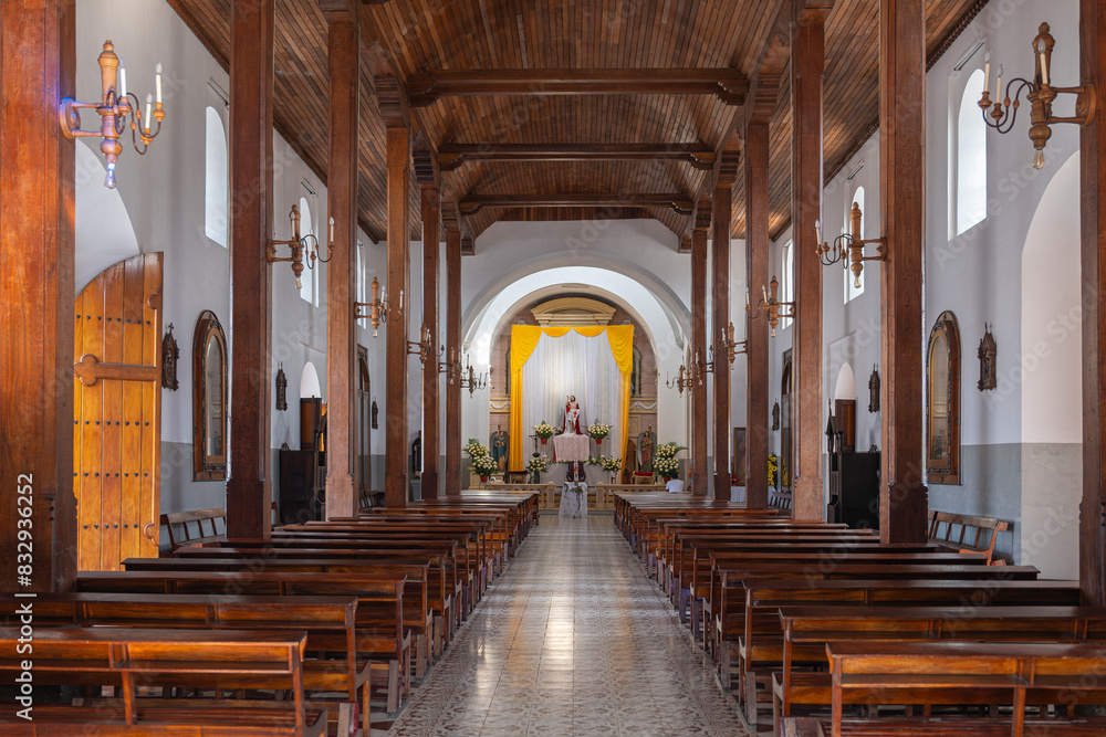 Interior of an empty old catholic church with wooden ceiling and column ...
