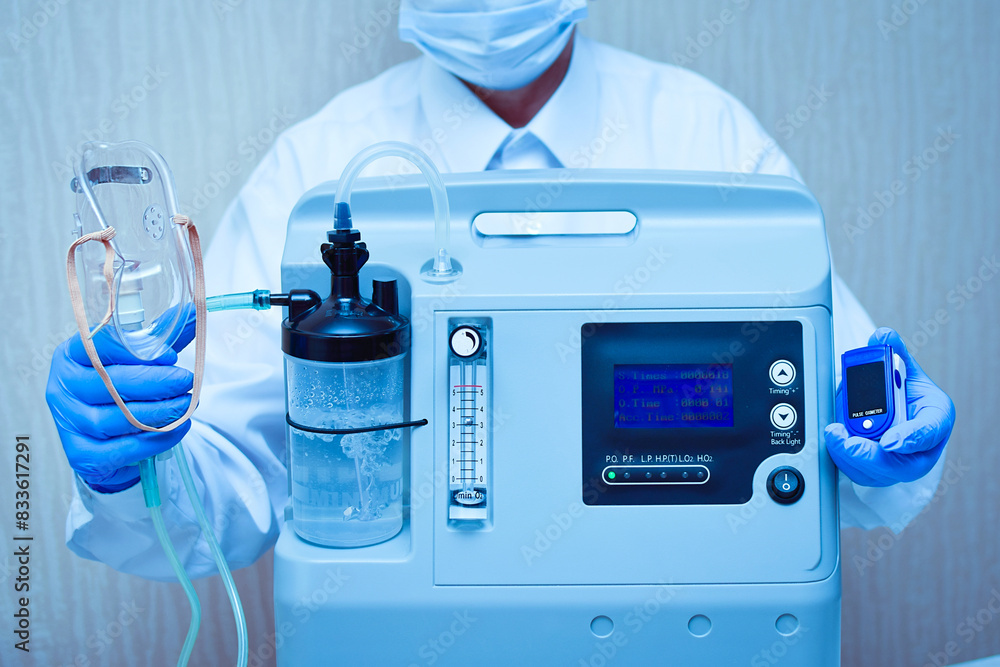 Hands in medical gloves hold an oxygen mask from the generator oxygen ...