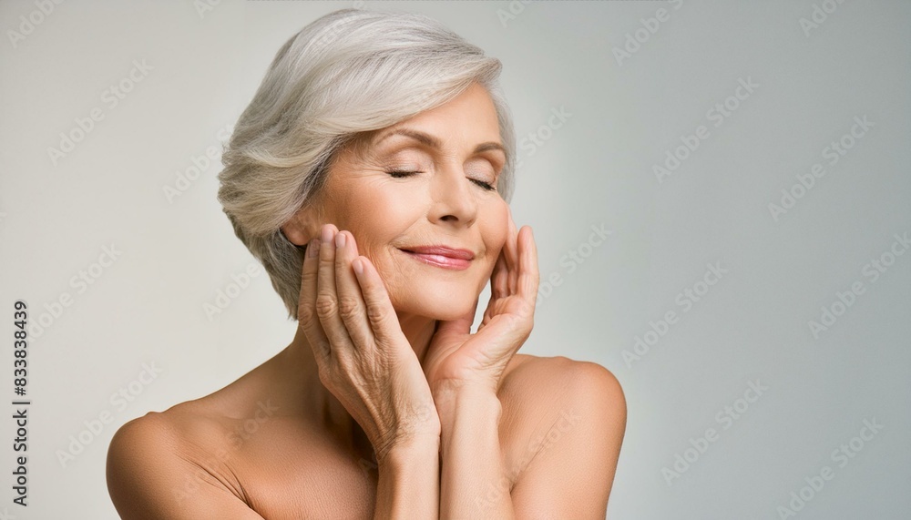 gorgeous senior older woman with closed eyes touching her perfect face ...