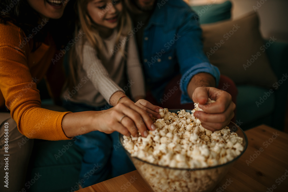 Family watching a movie and grabbing a popcorn all together with a ...