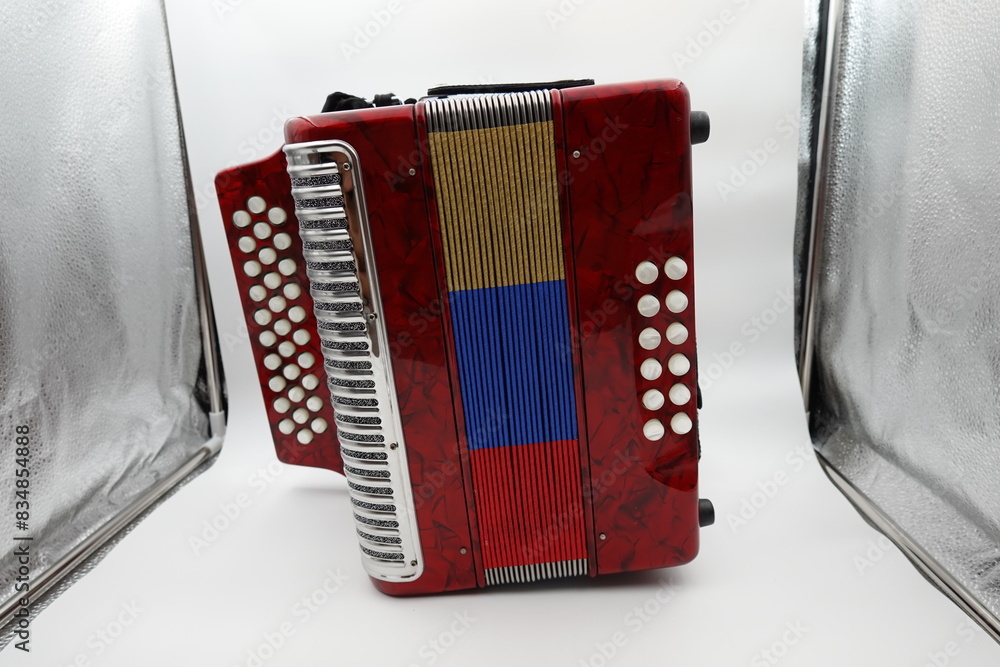 A vibrant red Colombian vallenato accordion featuring the colors of the ...