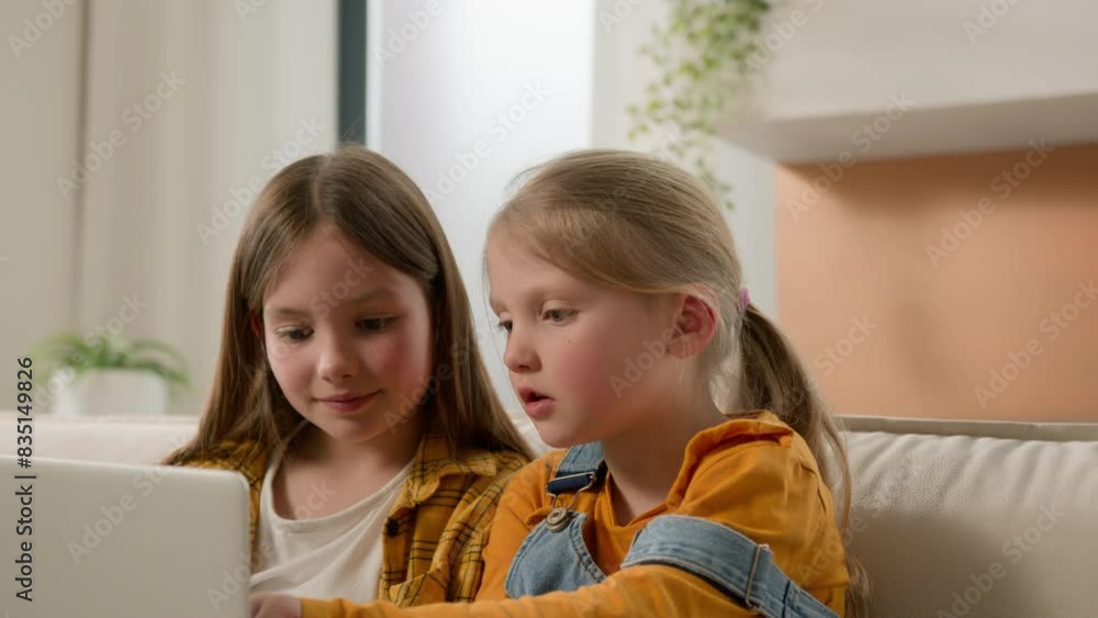 Two happy little Caucasian girls kids daughters children watching film ...