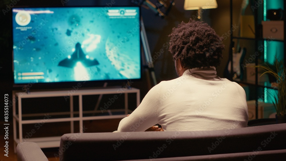 Gamer plays multiplayer game with spaceship shooting laser streams ...