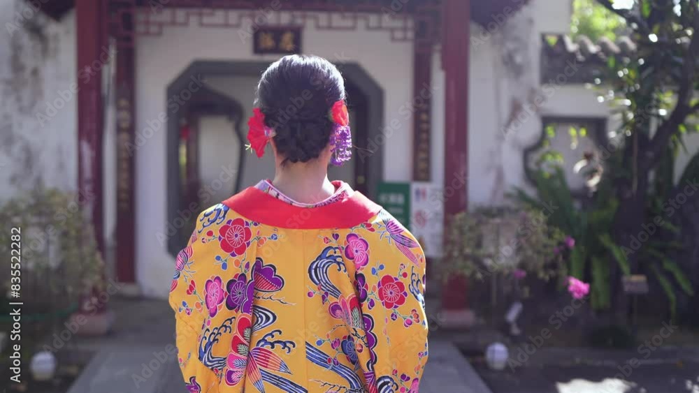 A young woman in her twenties, wearing traditional Ryusou, strolls ...