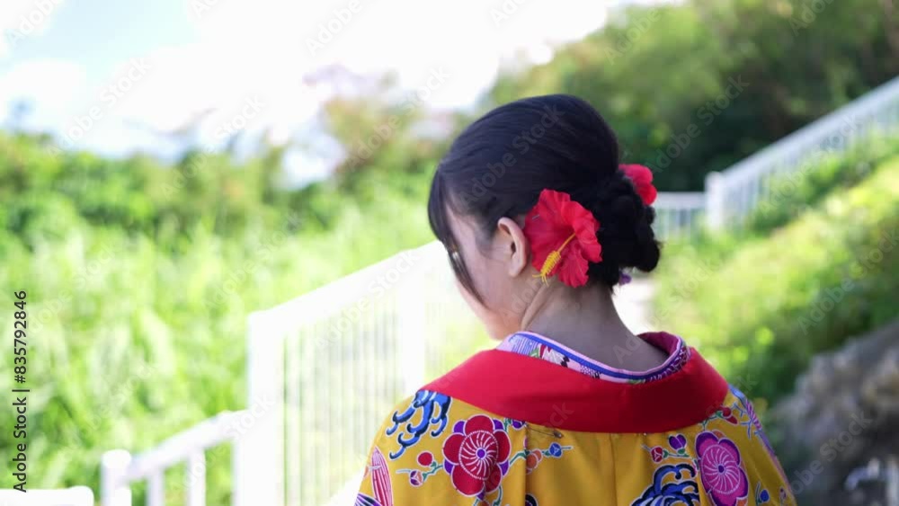 A young woman in her twenties, wearing traditional Ryusou, is walking ...