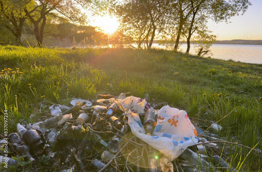 Garbage dump on beach at lake. People throw garbage near lake in nature ...